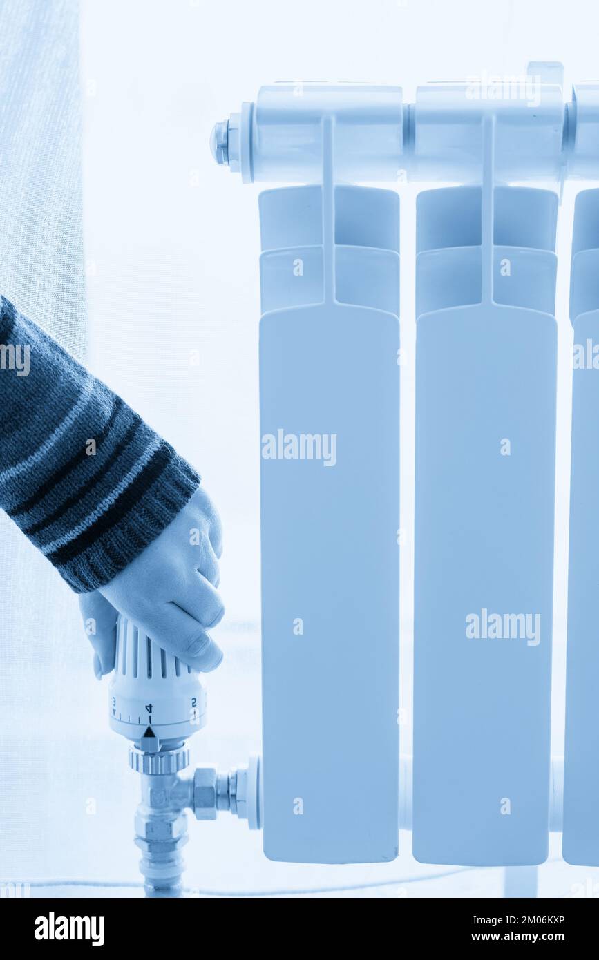 Radiator adjustment closeup. Female hand adjusting radiator temperature ...