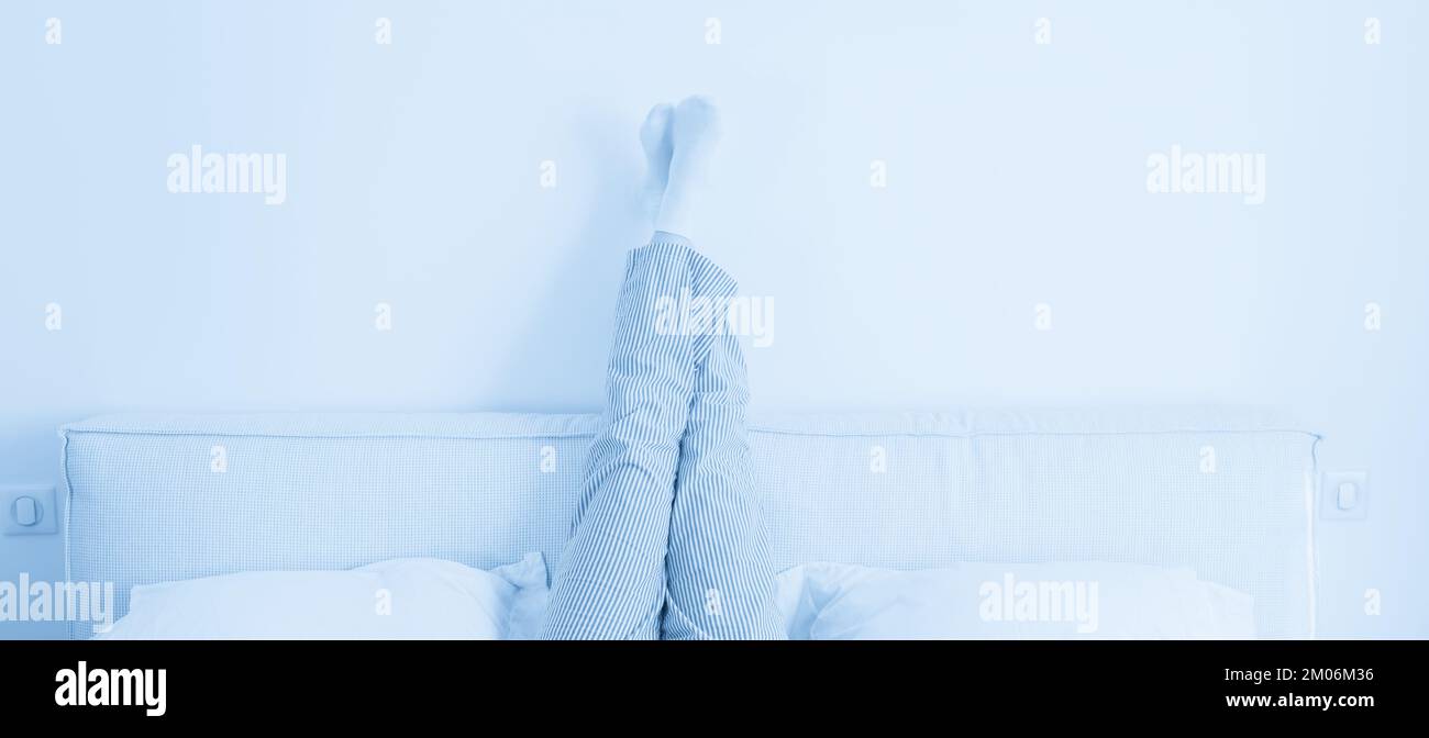 Panorama of female legs raised up high lying on bed in bedroom Stock ...