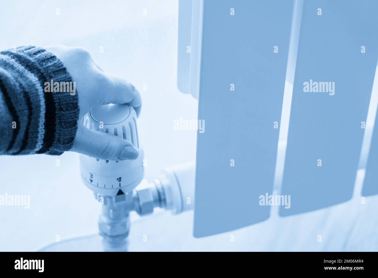 Radiator adjustment closeup. Female hand adjusting radiator temperature ...