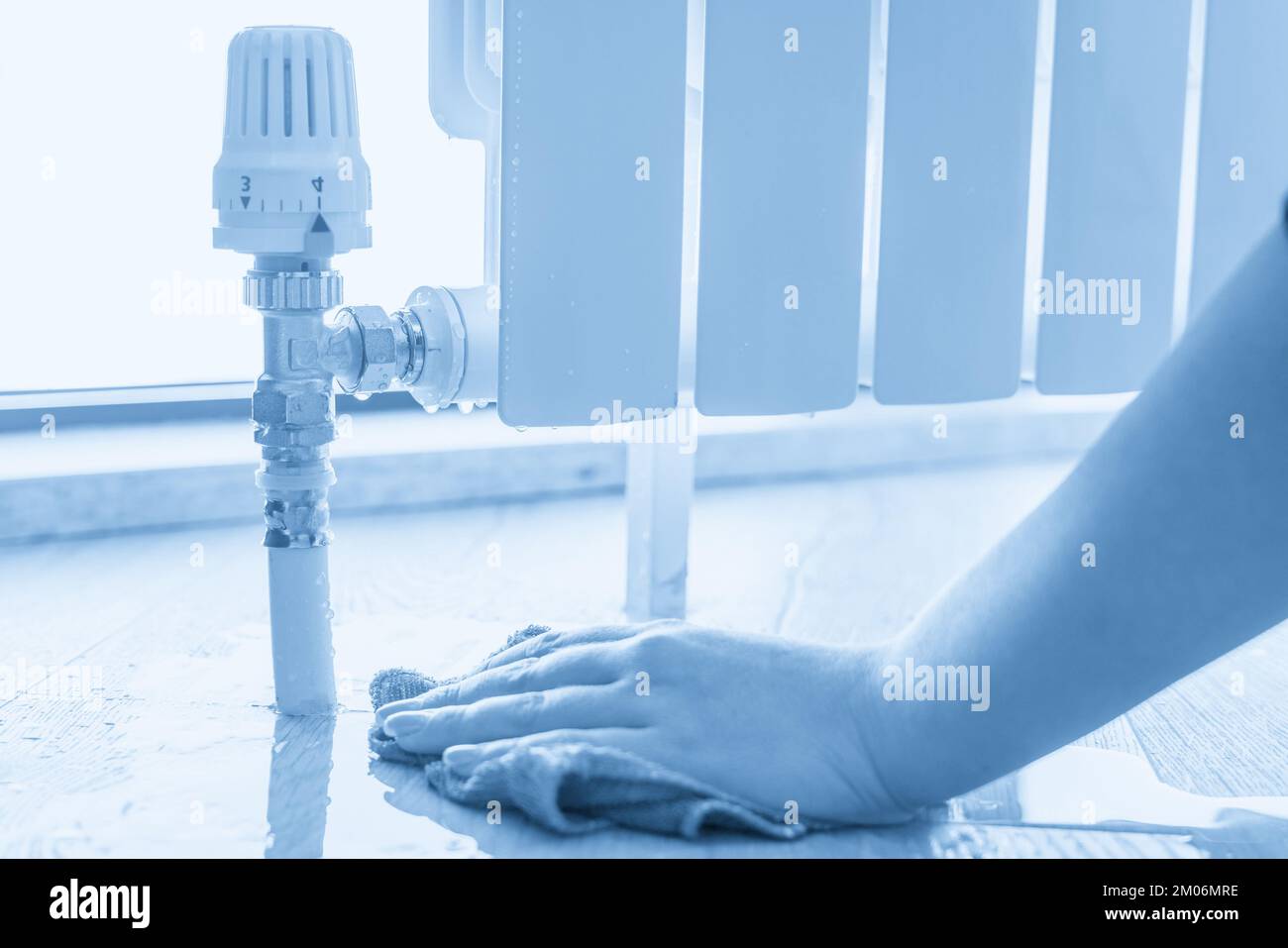 Female hand with rag cleaning water from heating radiator leak Stock ...