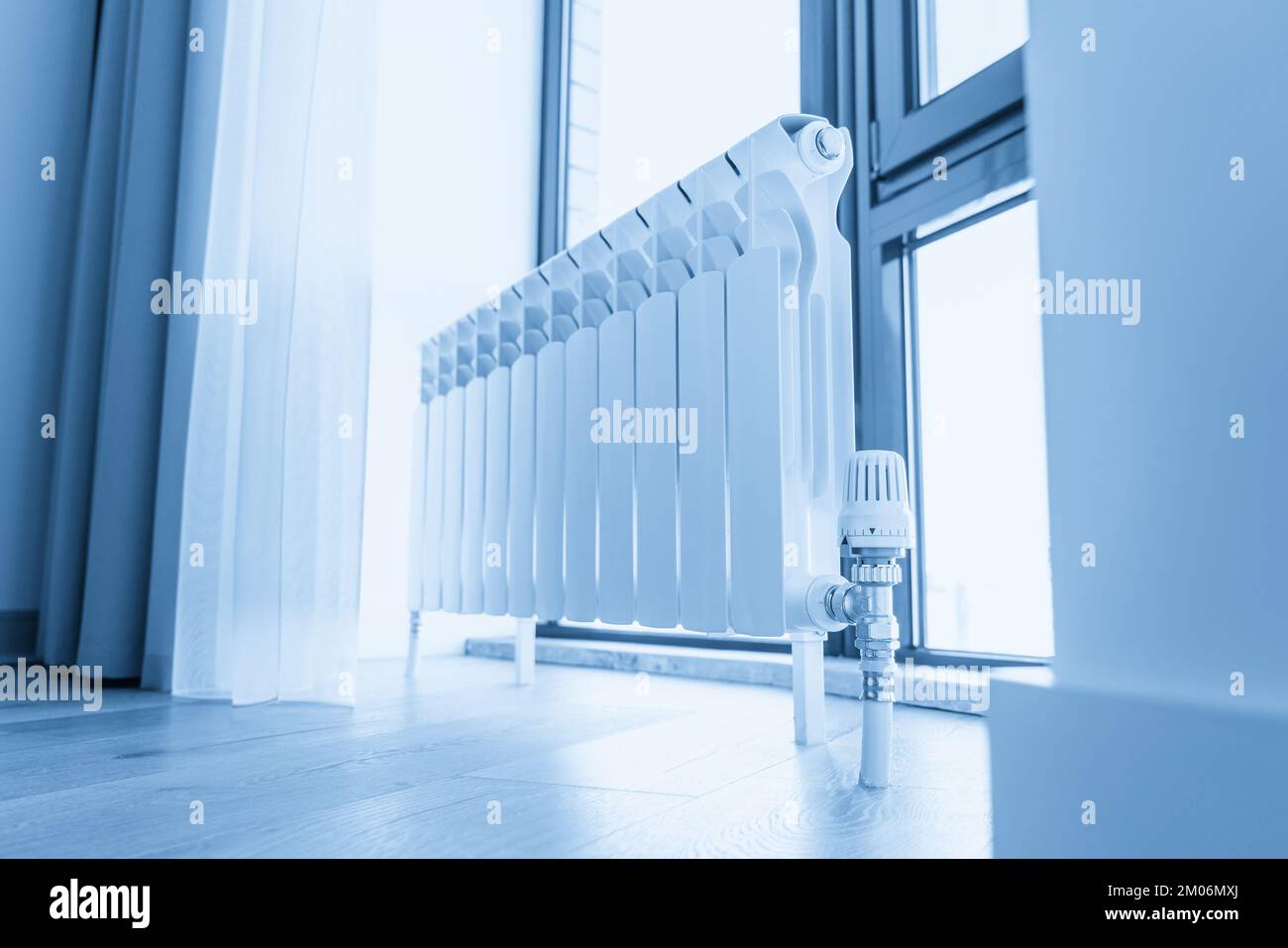 White big radiator with thermostat near window in modern room Stock ...