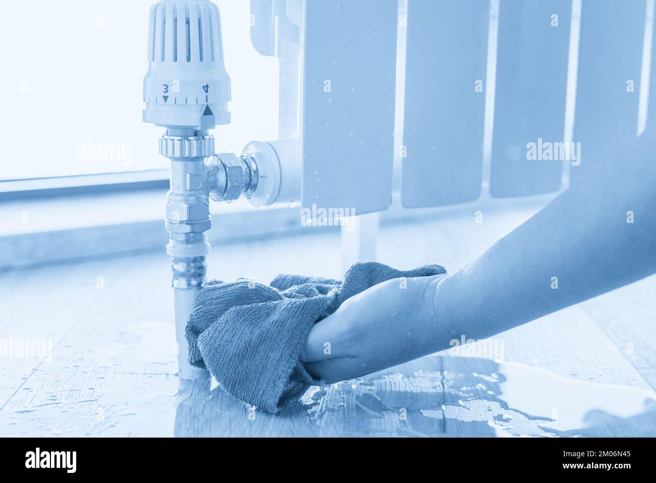 Female hand with rag cleaning water from heating radiator leak Stock ...