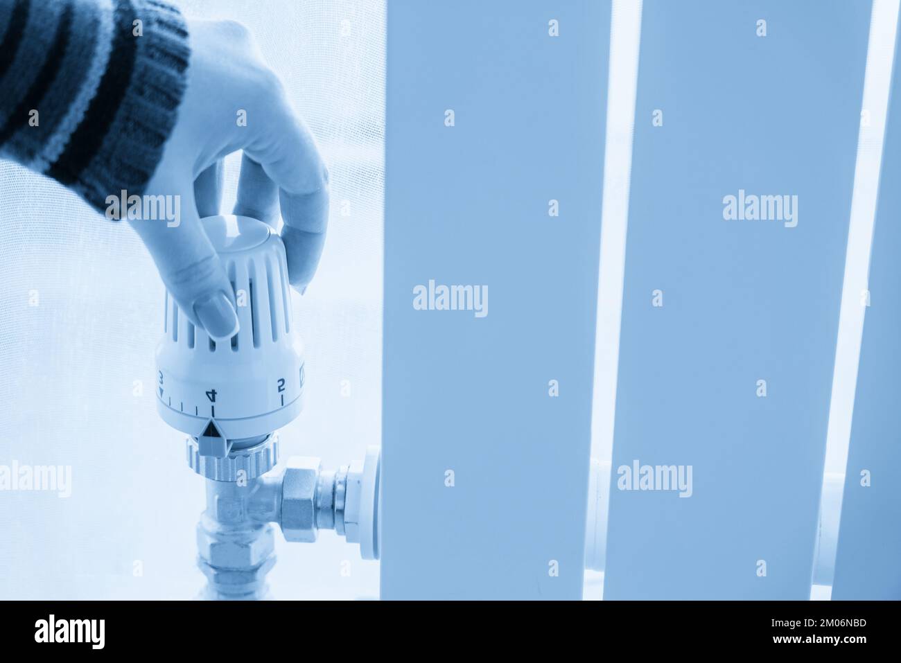 Radiator adjustment closeup. Female hand adjusting radiator temperature ...