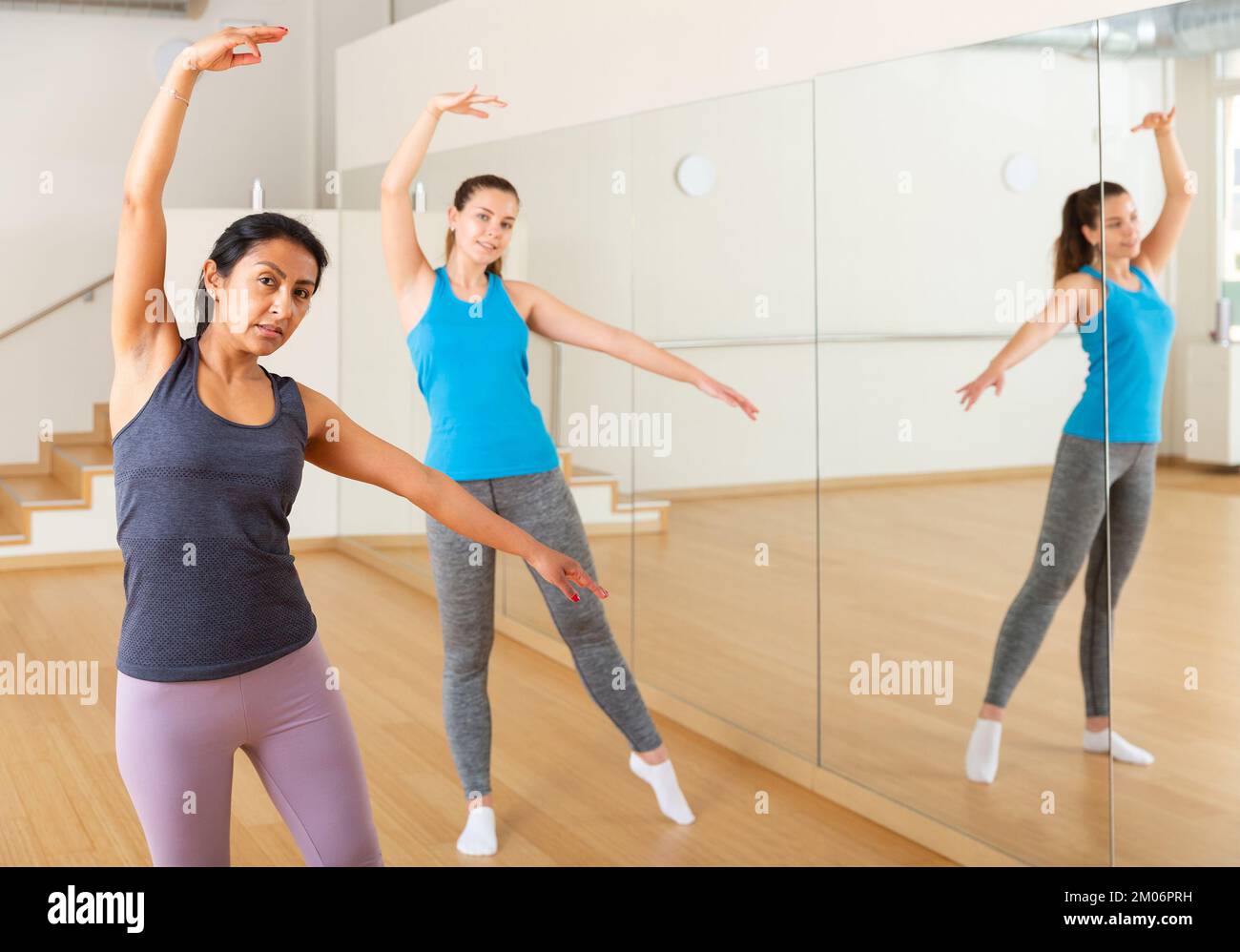 Hispanic woman practicing classic dance moves during group class Stock ...
