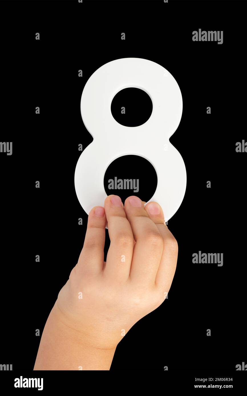 Number eight in hand isolated on black background. Number 8 in a child ...