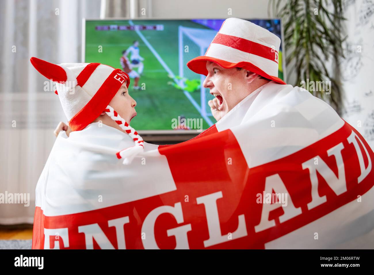 Father and son with England flag watching soccer game on TV Stock Photo ...