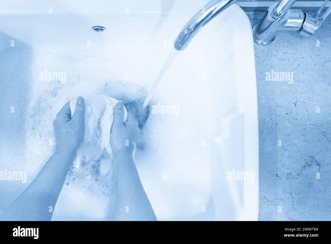 Female hands washing color clothes in sink with copy space Stock Photo ...