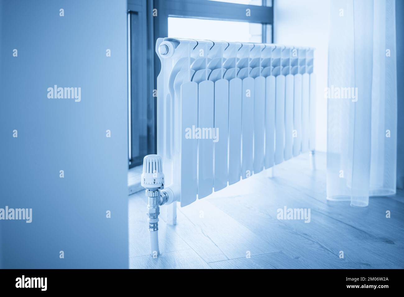 White big radiator with thermostat near window in modern room Stock ...