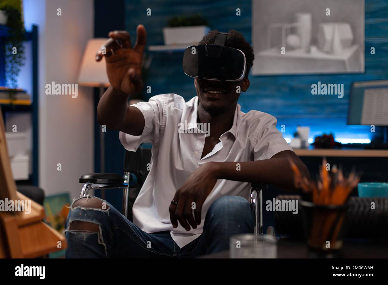 Modern artist with walking disease using virtual reality goggles to ...