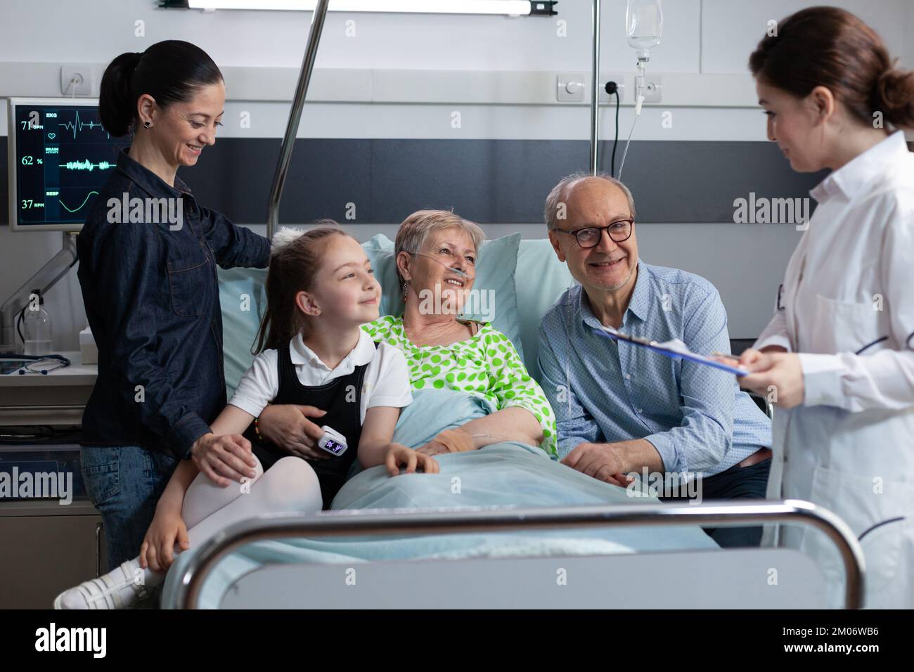 Hospital medical staff member informing elderly female patient family ...