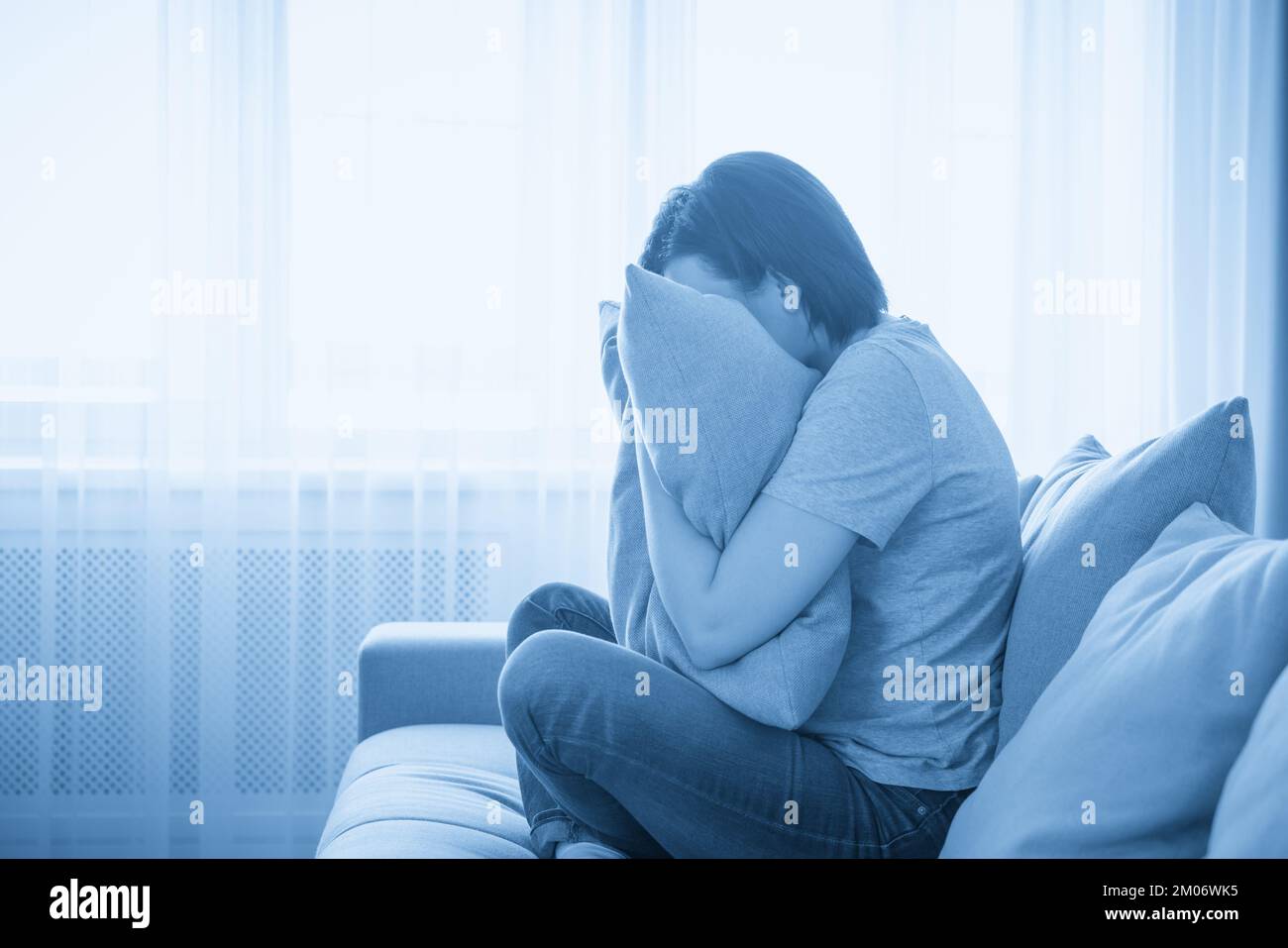 Sad depressed woman crying at pillow, loneliness and sadness concept ...