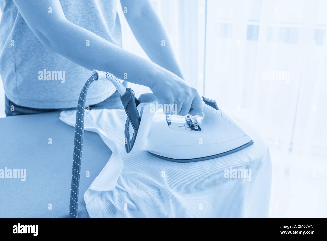 Female hands ironing white shirt on ironing board Stock Photo - Alamy