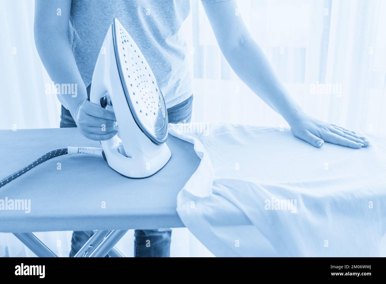 Female hands ironing white shirt on ironing board Stock Photo - Alamy