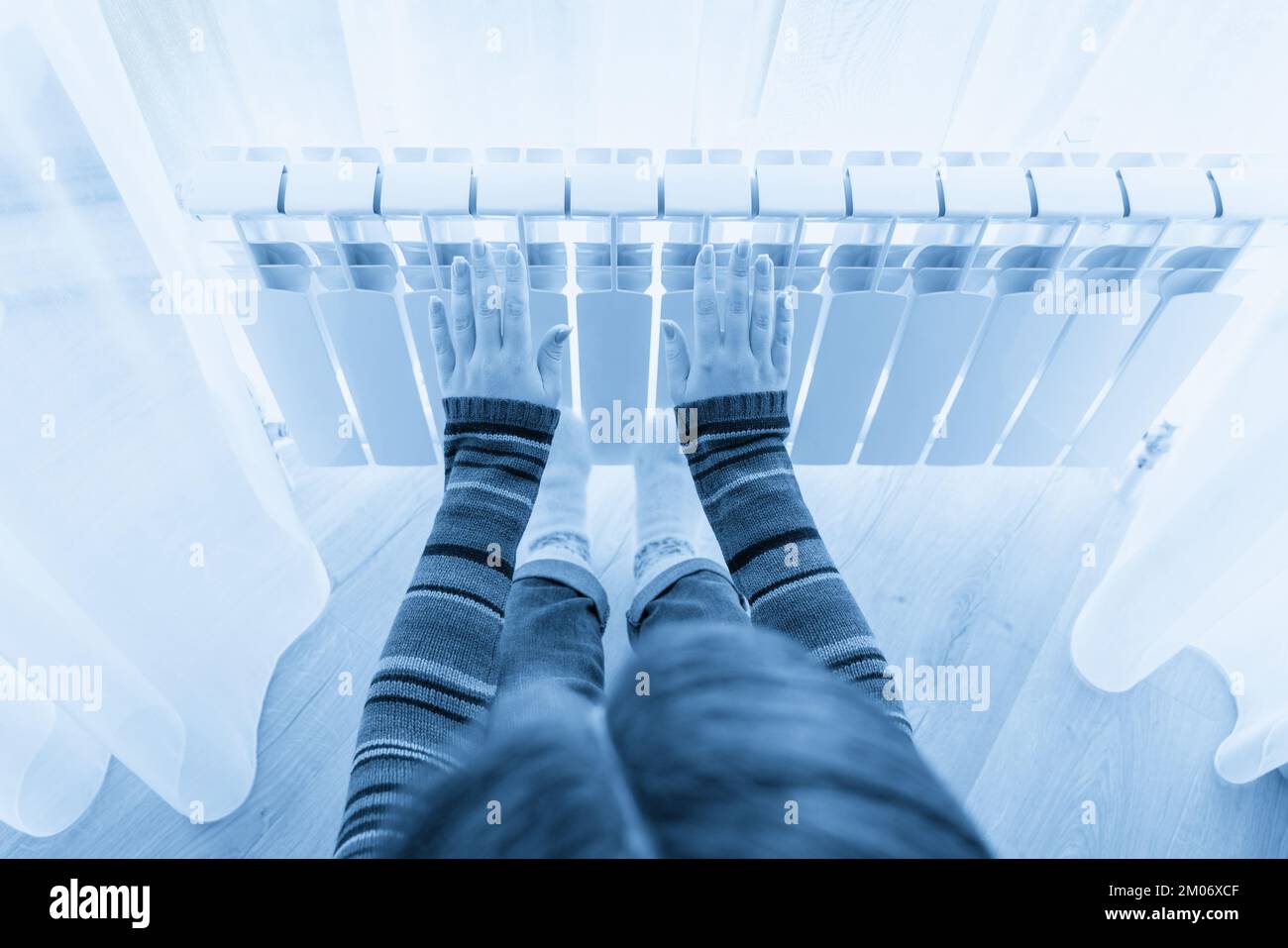 Girl warms up the frozen hands above hot radiator, close up view Stock ...
