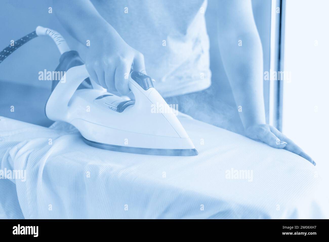 Female hands ironing white shirt on ironing board Stock Photo - Alamy
