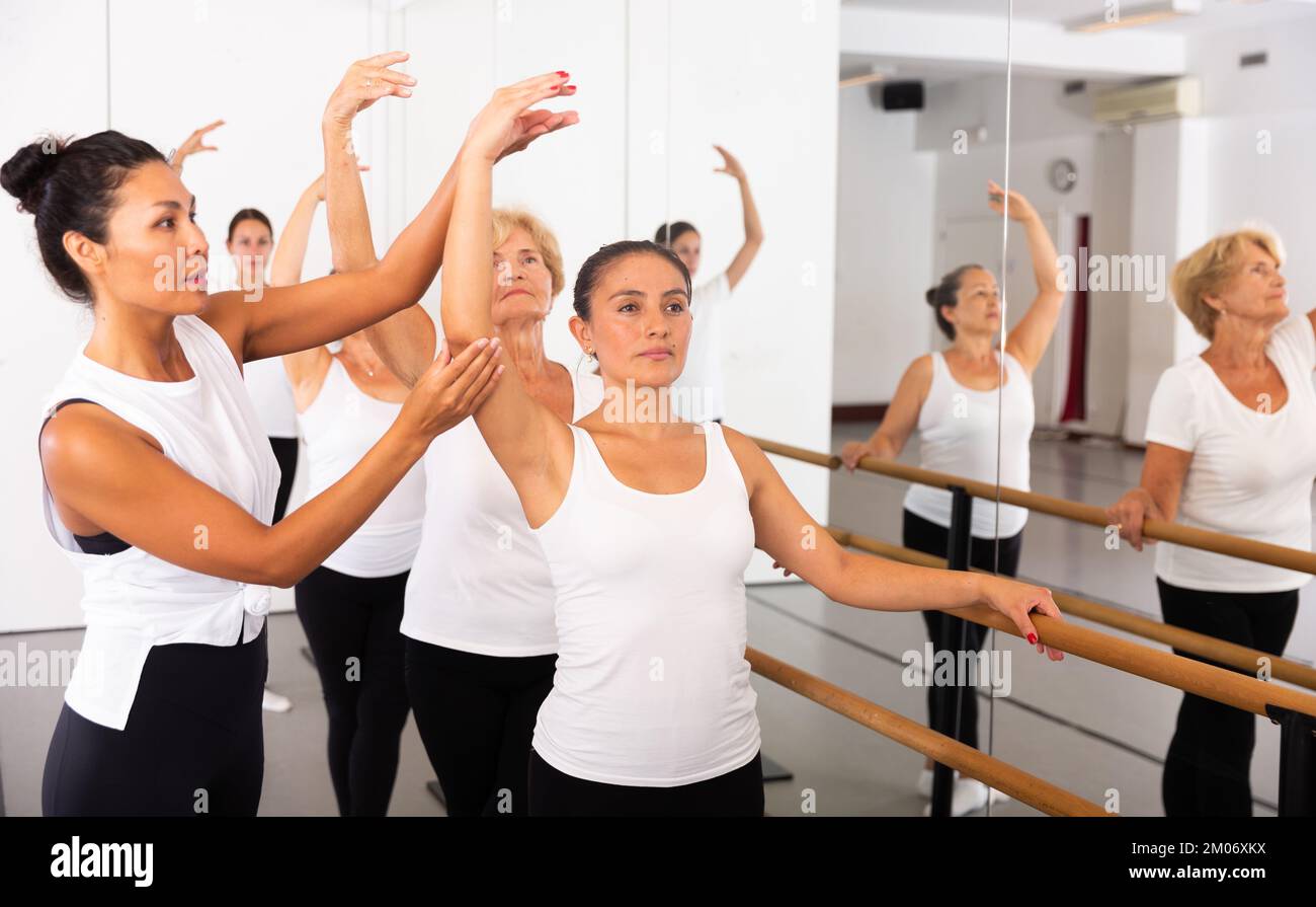 Female choreographer and group of multiracial dancers in dance school ...
