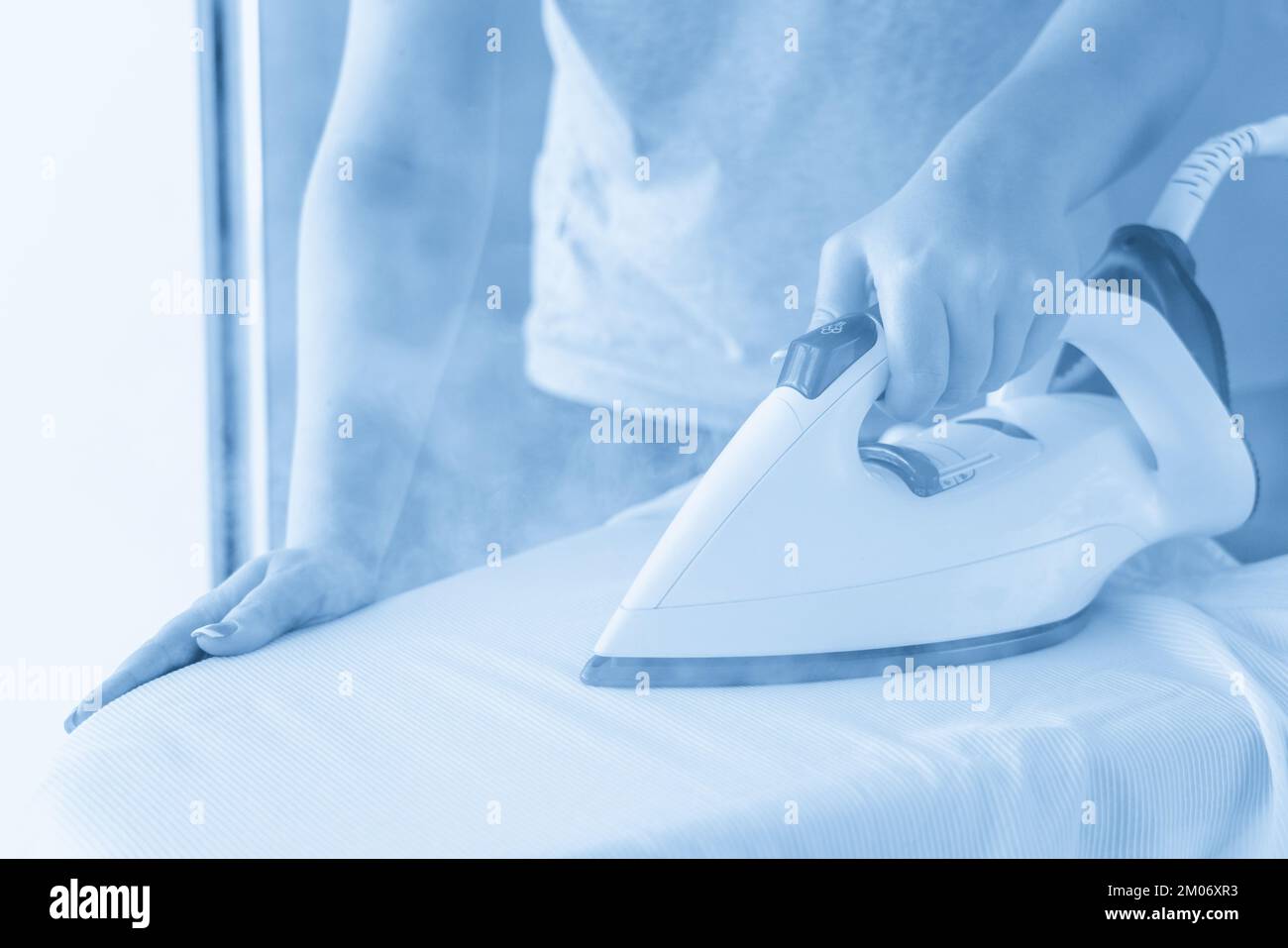 Female hands ironing white shirt on ironing board Stock Photo - Alamy