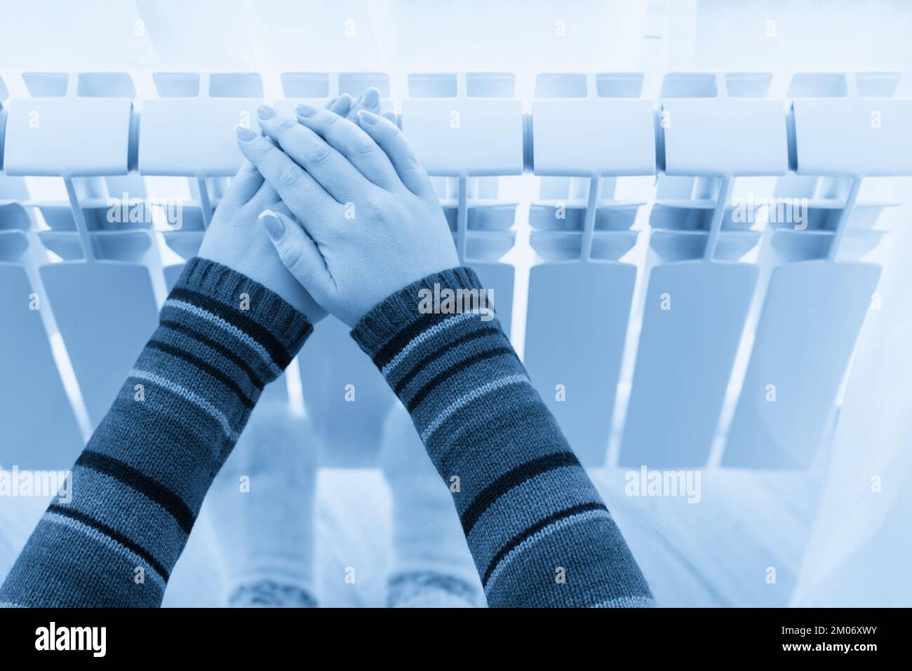 Girl warms up the frozen hands above hot radiator, close up view Stock ...