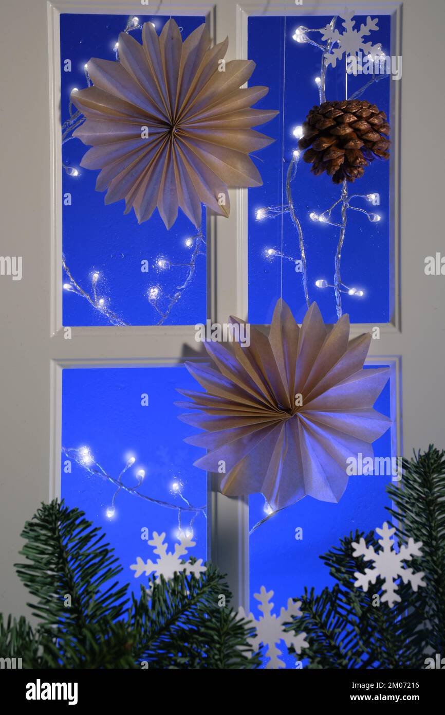Simple paper Christmas stars and lights hanging in window. Decorated ...