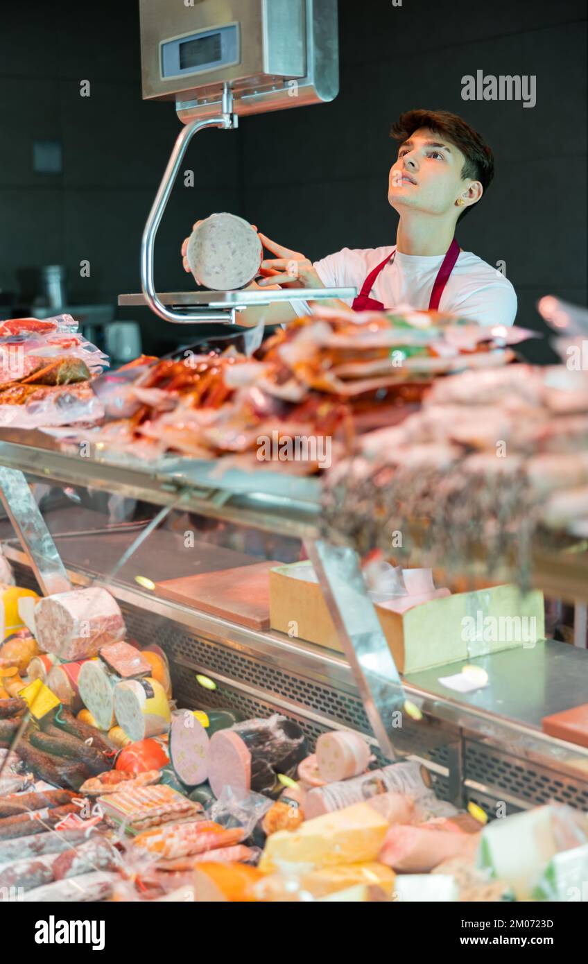 Male shop seller using scales for meat in butcher shop Stock Photo - Alamy