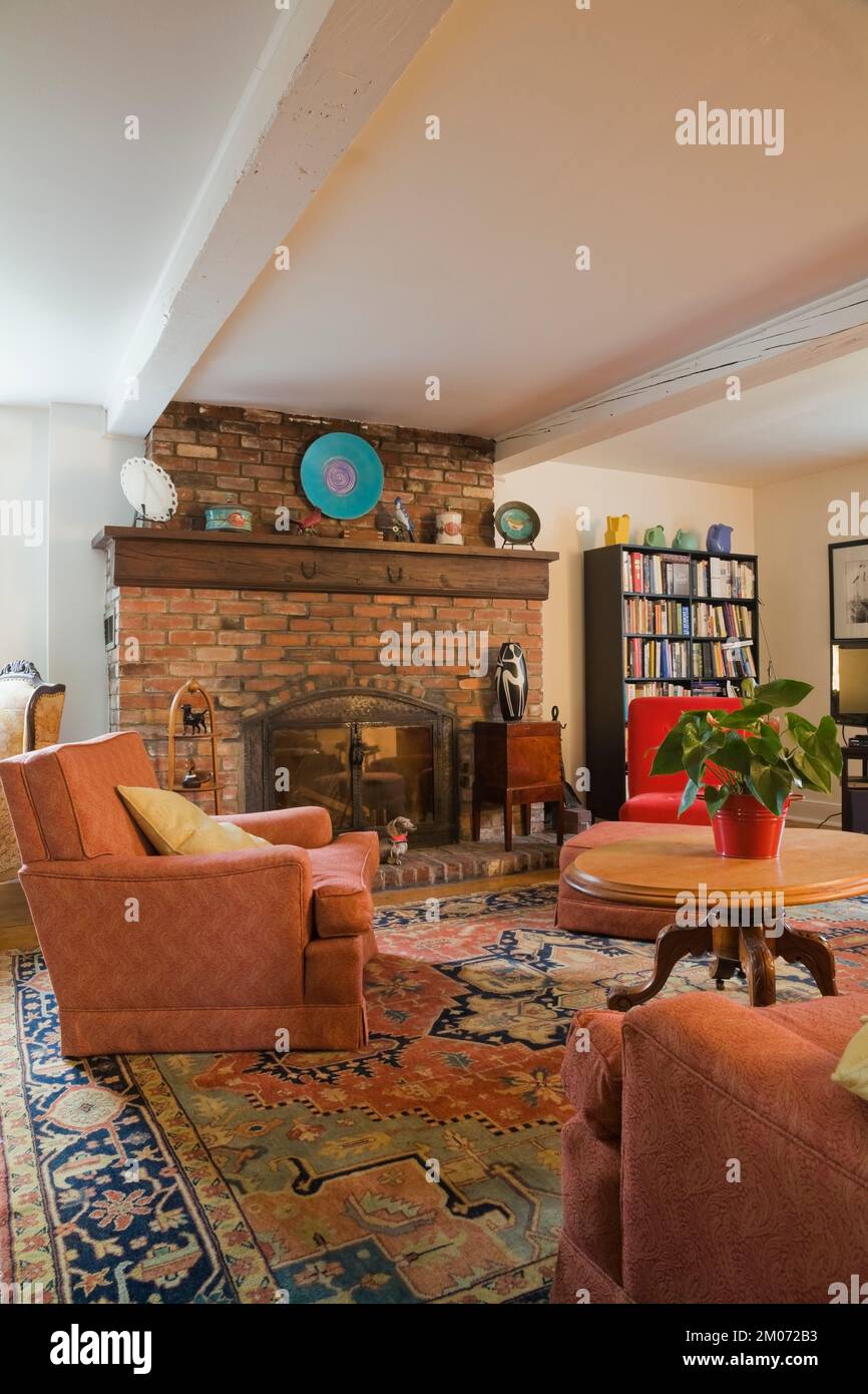 Salmon colored upholstered sofa, oval wood coffee table and red brick ...