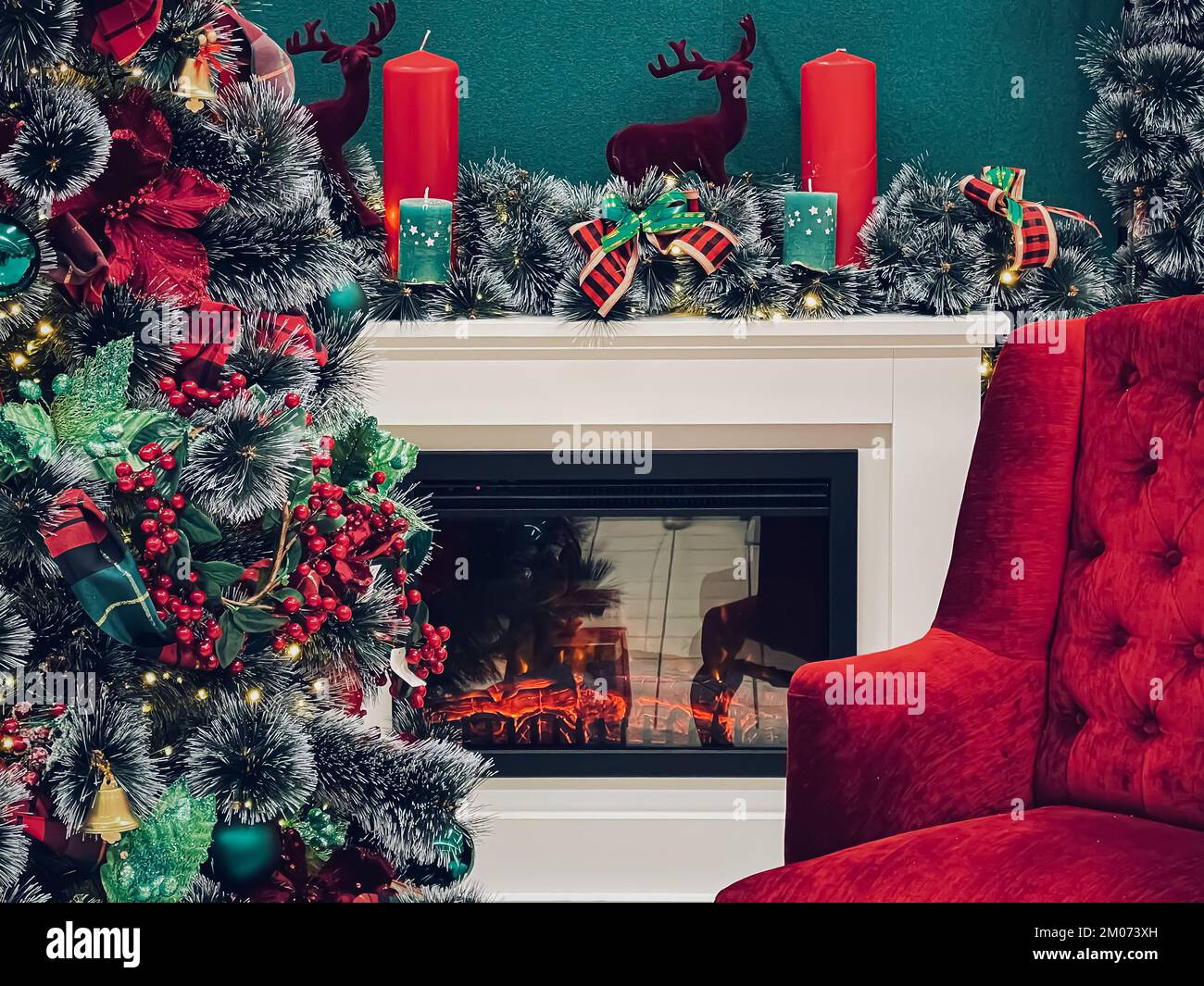 Festive Christmas tree and decorations next to decorated fireplace in ...