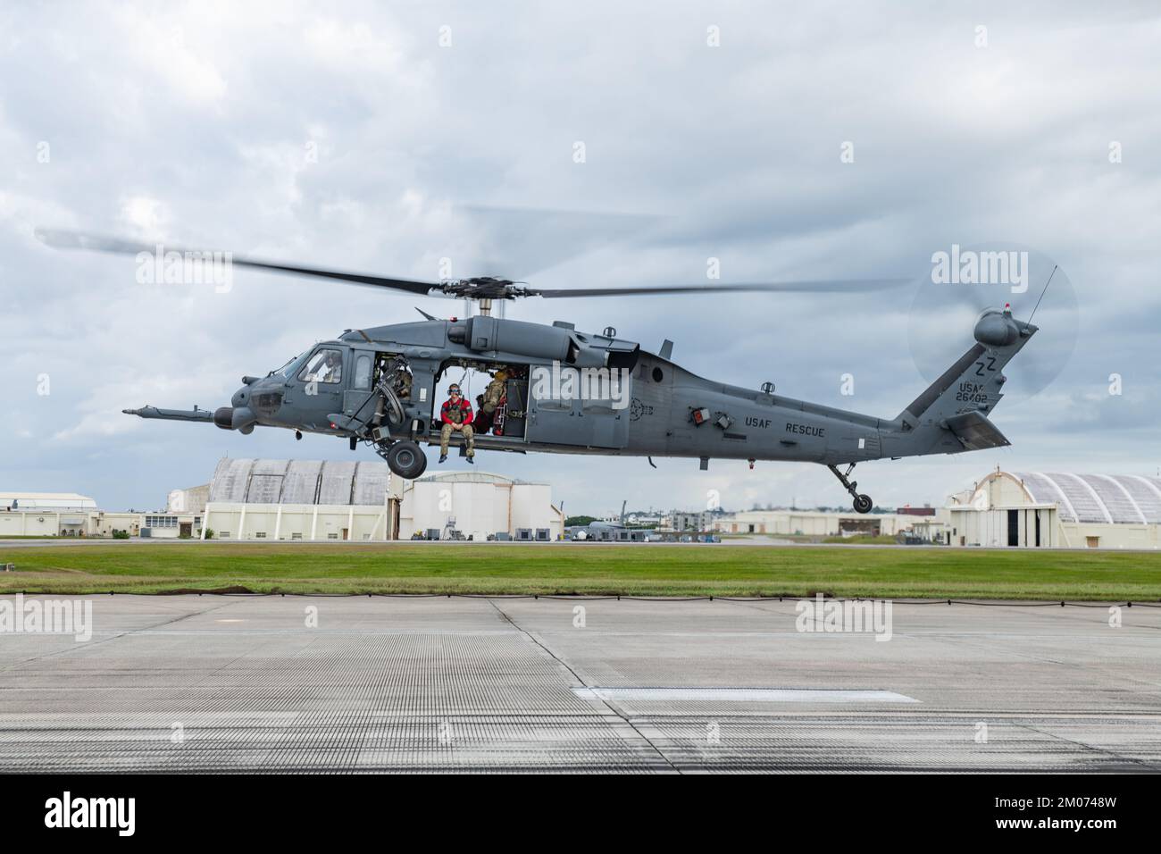 A 33rd Rescue Squadron HH-60 Pave Hawk hovers over a flight line in preparation for a large ...