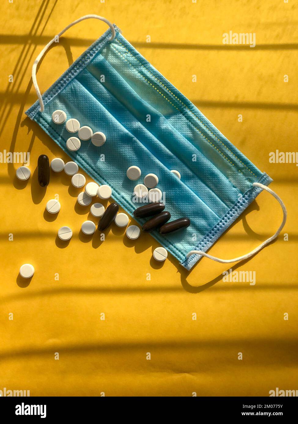 Vitamins and doctor s mask, corona virus protection concept on yellow ...