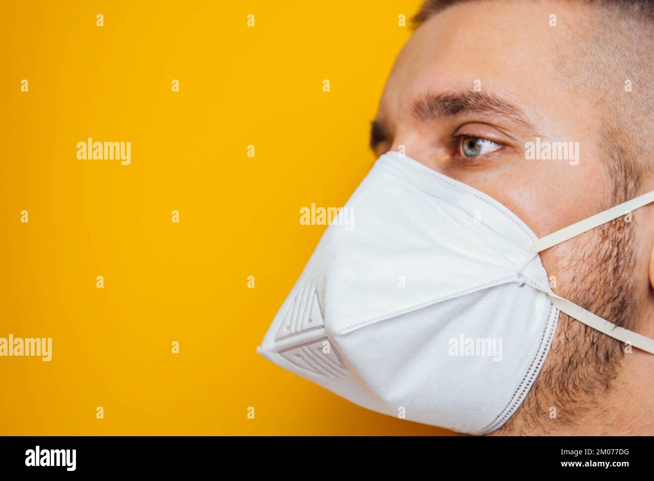 Corona virus. Young guy in a respirator on a yellow background ...
