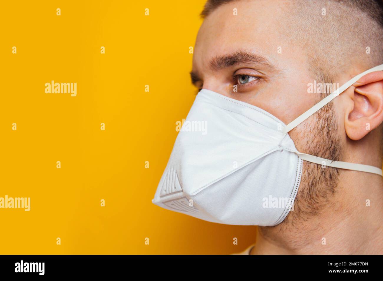 Corona virus. Young guy in a respirator on a yellow background ...