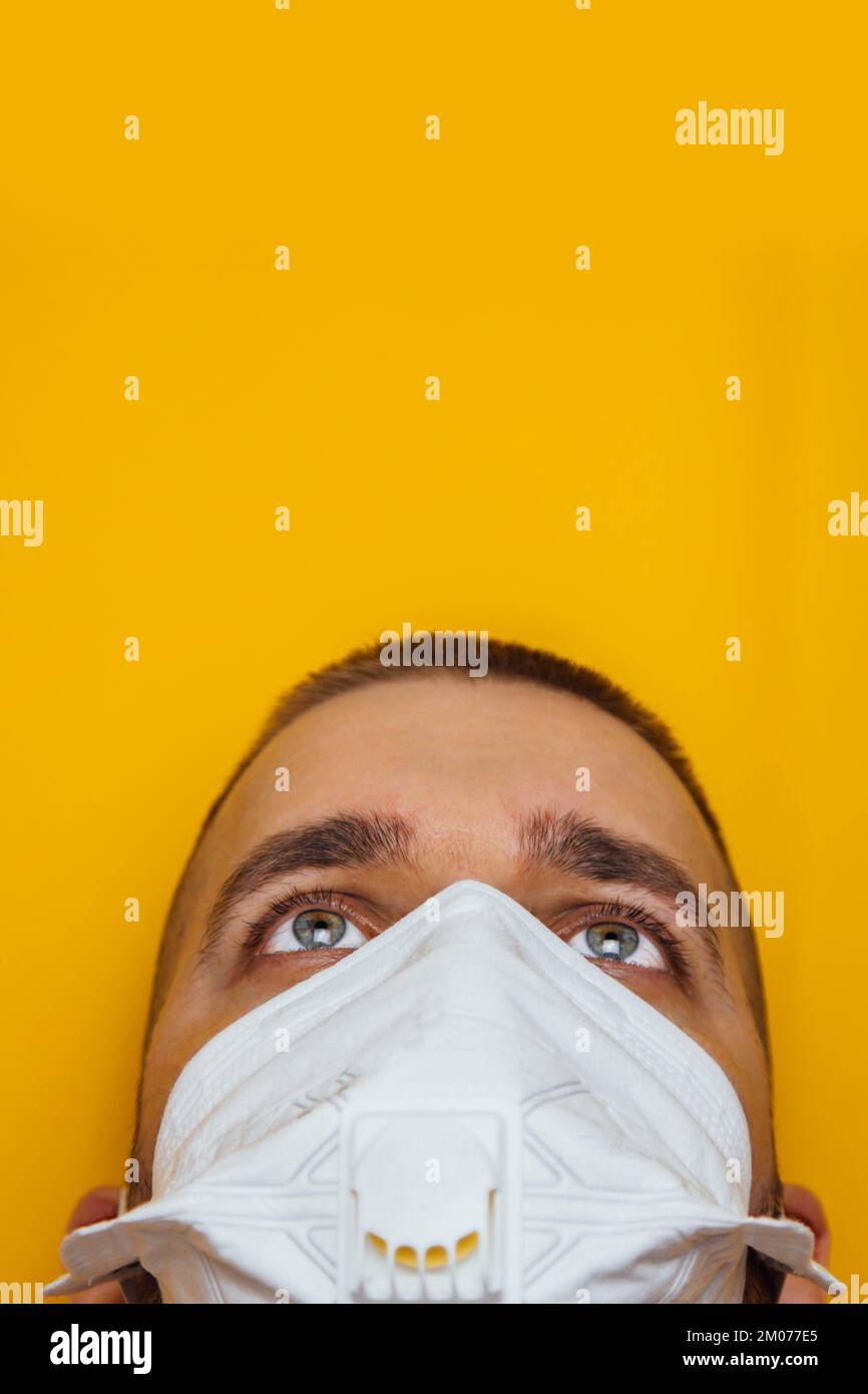 Corona virus. Young guy in a respirator on a yellow background ...