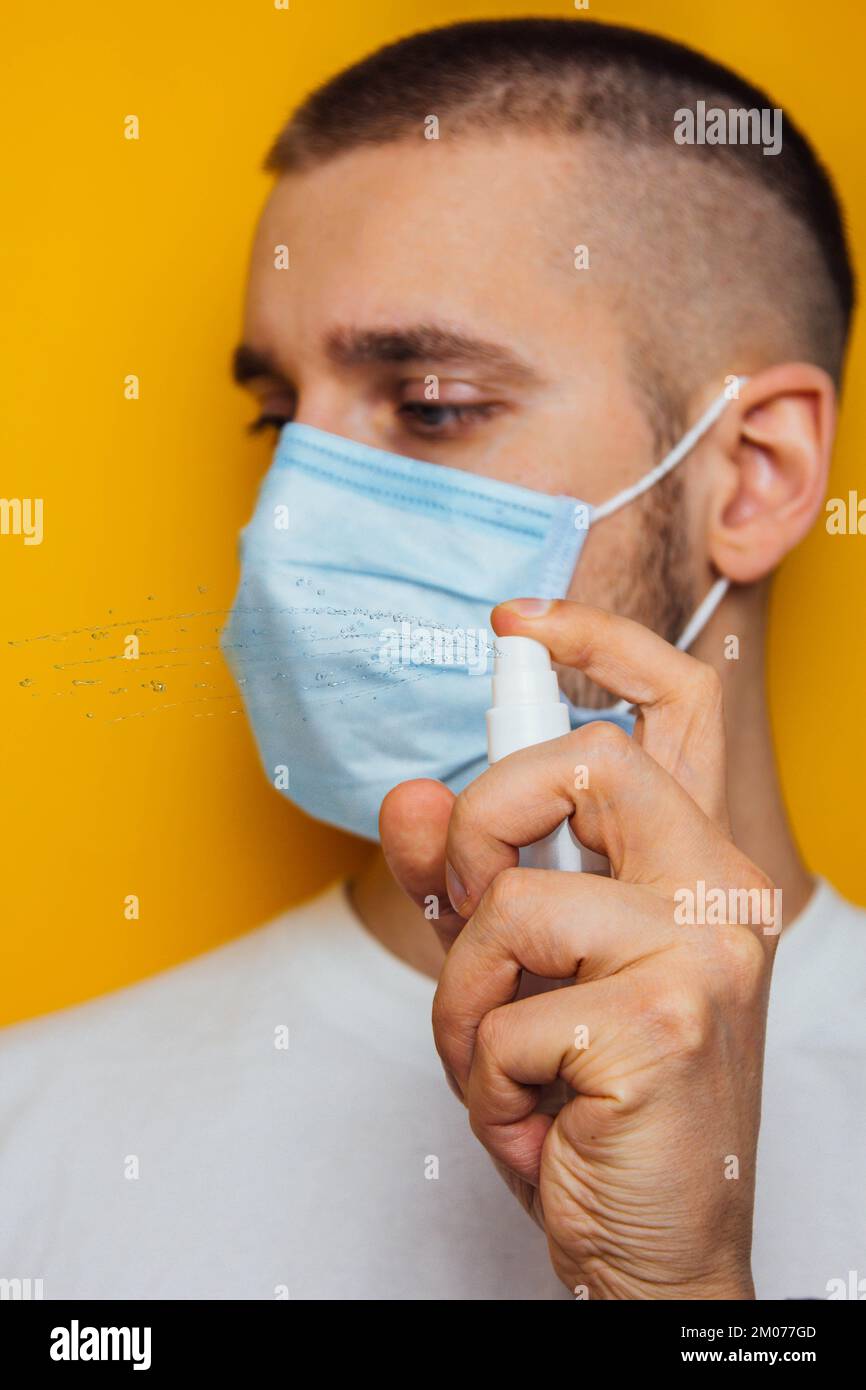 Portrait of a young doctor in a respirator on a yellow background ...