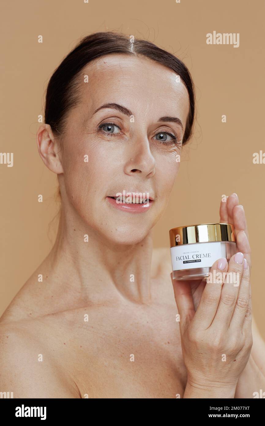 modern woman with facial cream jar on beige background Stock Photo - Alamy