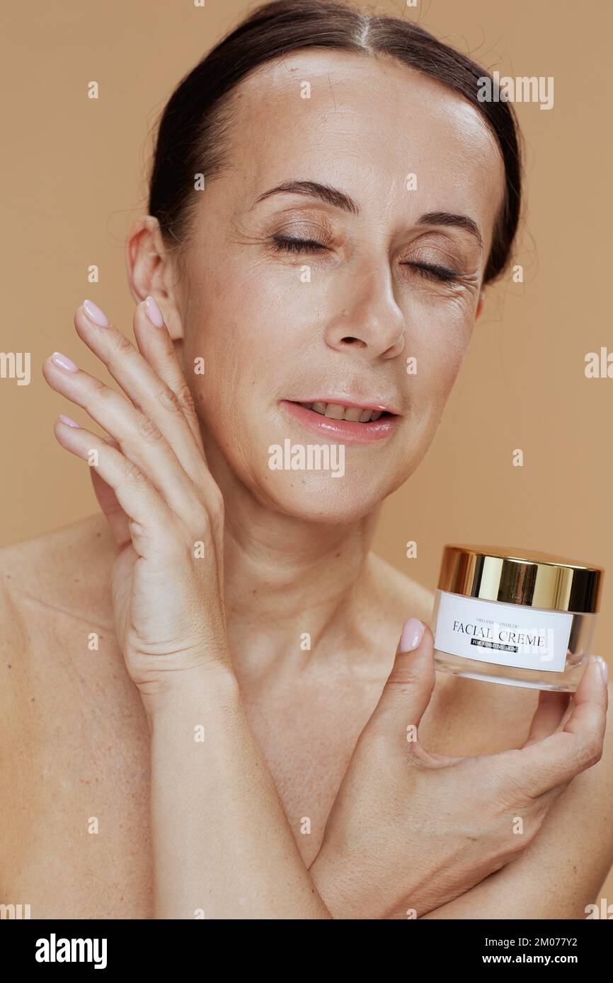 modern woman with facial cream jar isolated on beige background Stock ...