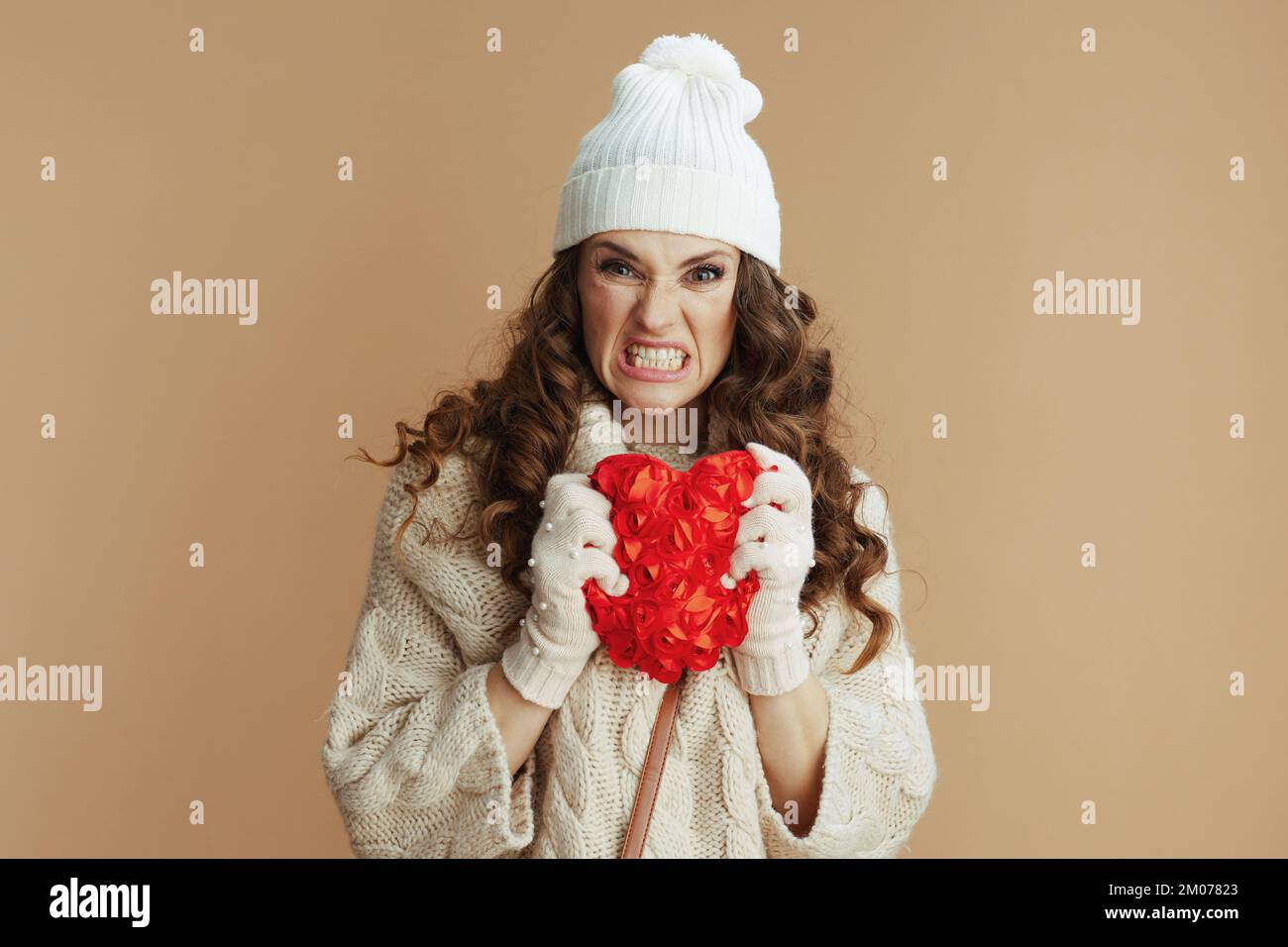 Hello winter. angry stylish woman in beige sweater, mittens and hat ...