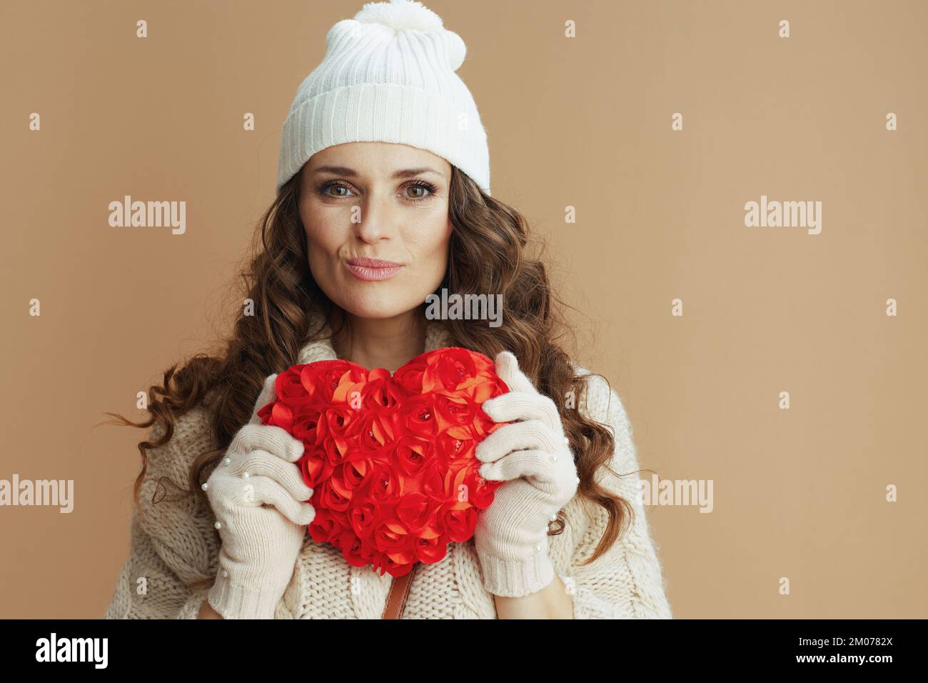 Hello winter. Portrait of stylish woman in beige sweater, mittens and ...