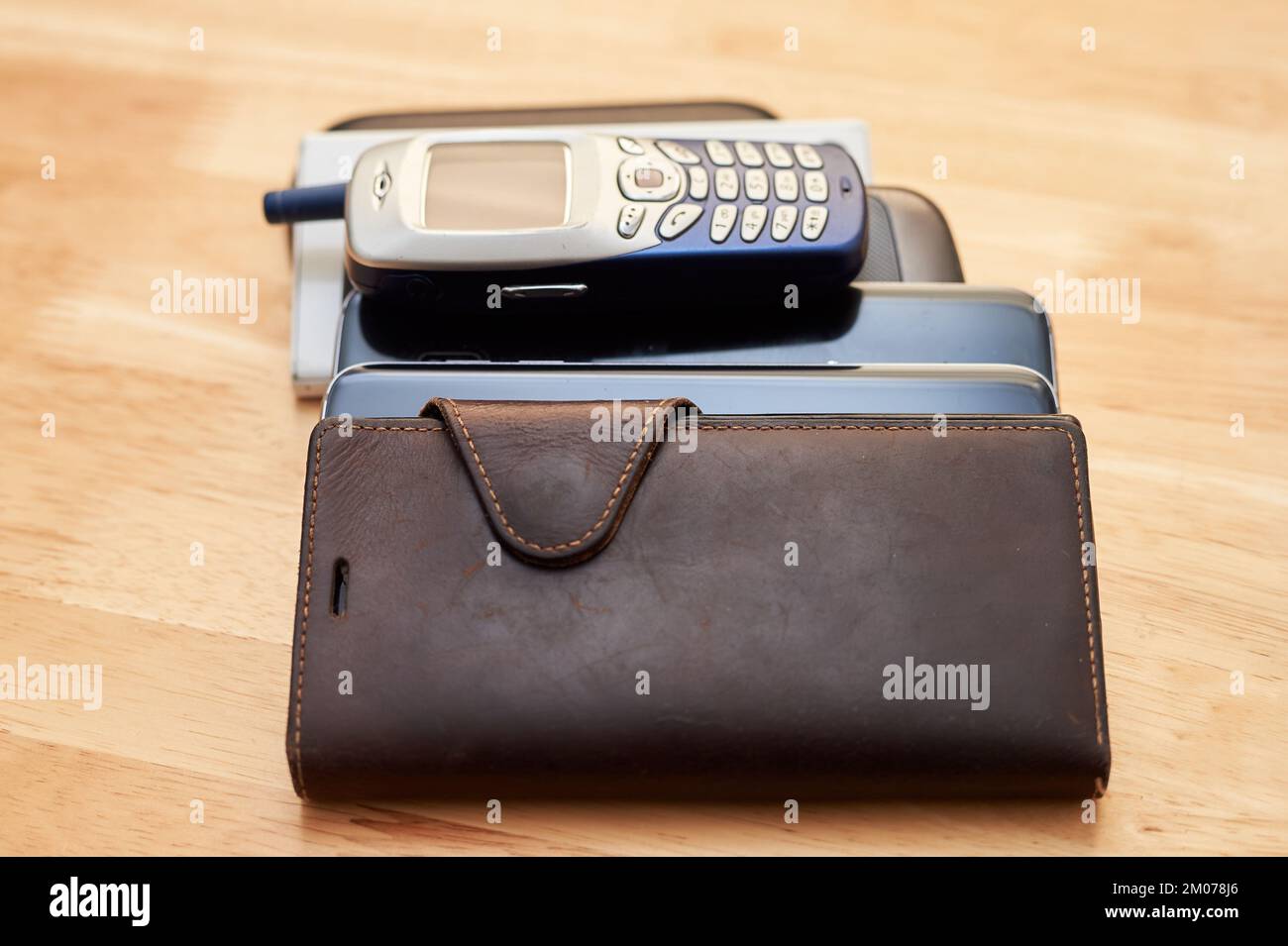 a bunch of old used up cell phones from different decades piled up on ...