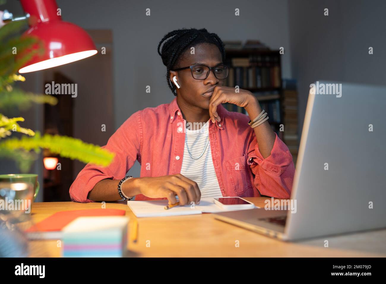 Exhausted bored African male student looking at laptop screen, feeling ...
