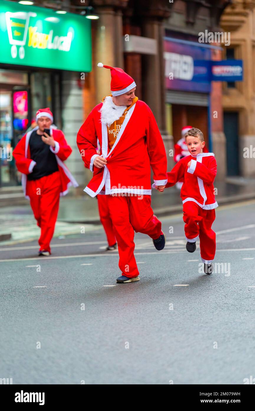 Runners race during the annual Liverpool Santa Dash. Thousands of ...