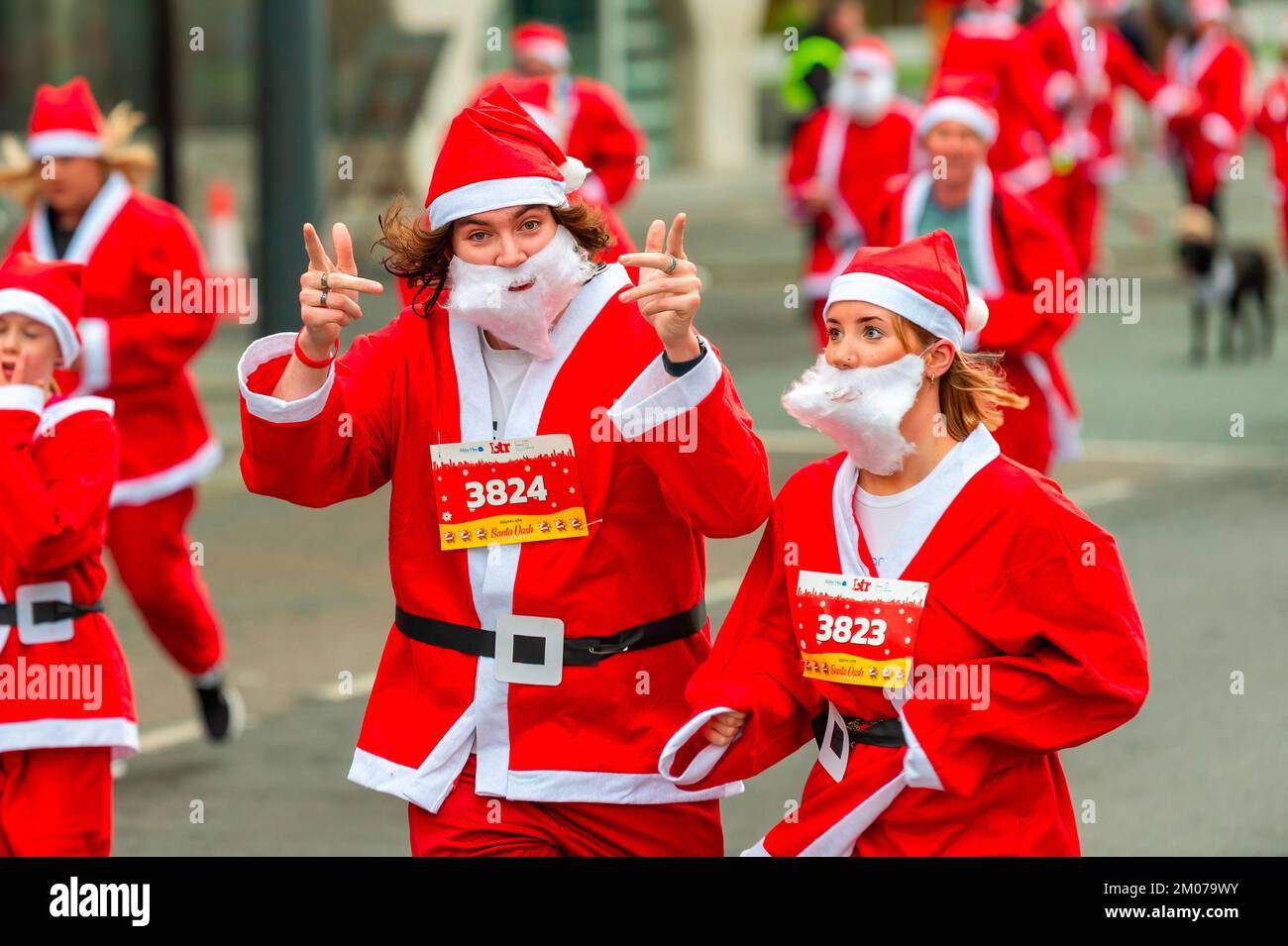 Runners race during the annual Liverpool Santa Dash. Thousands of ...