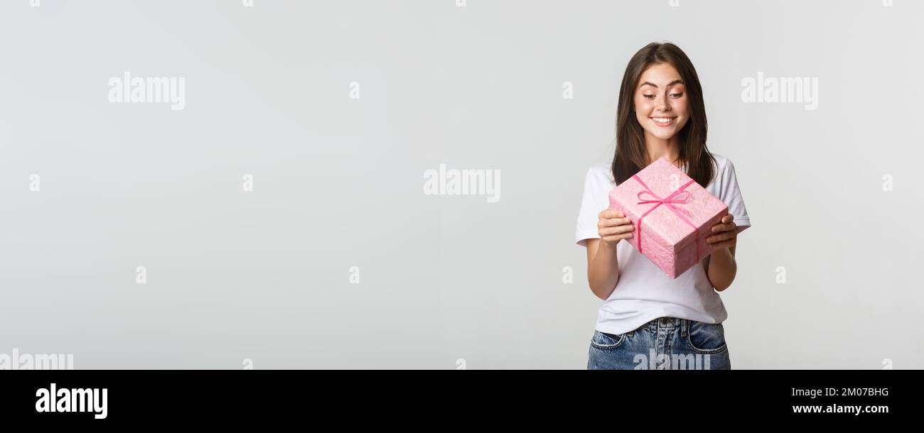 Happy cute young birthday girl, smiling and looking at b-day gift Stock ...