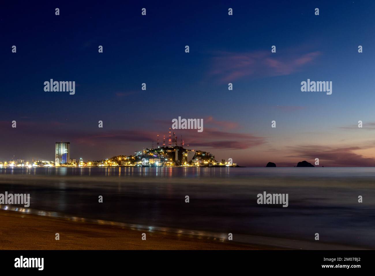 A Mazatlan sinaloa beach at night with luminous city in the background ...