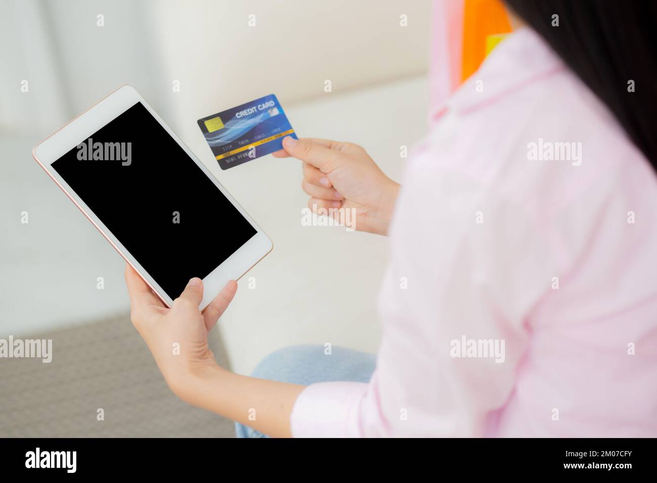 Young asian woman holding credit card shopping online with tablet ...