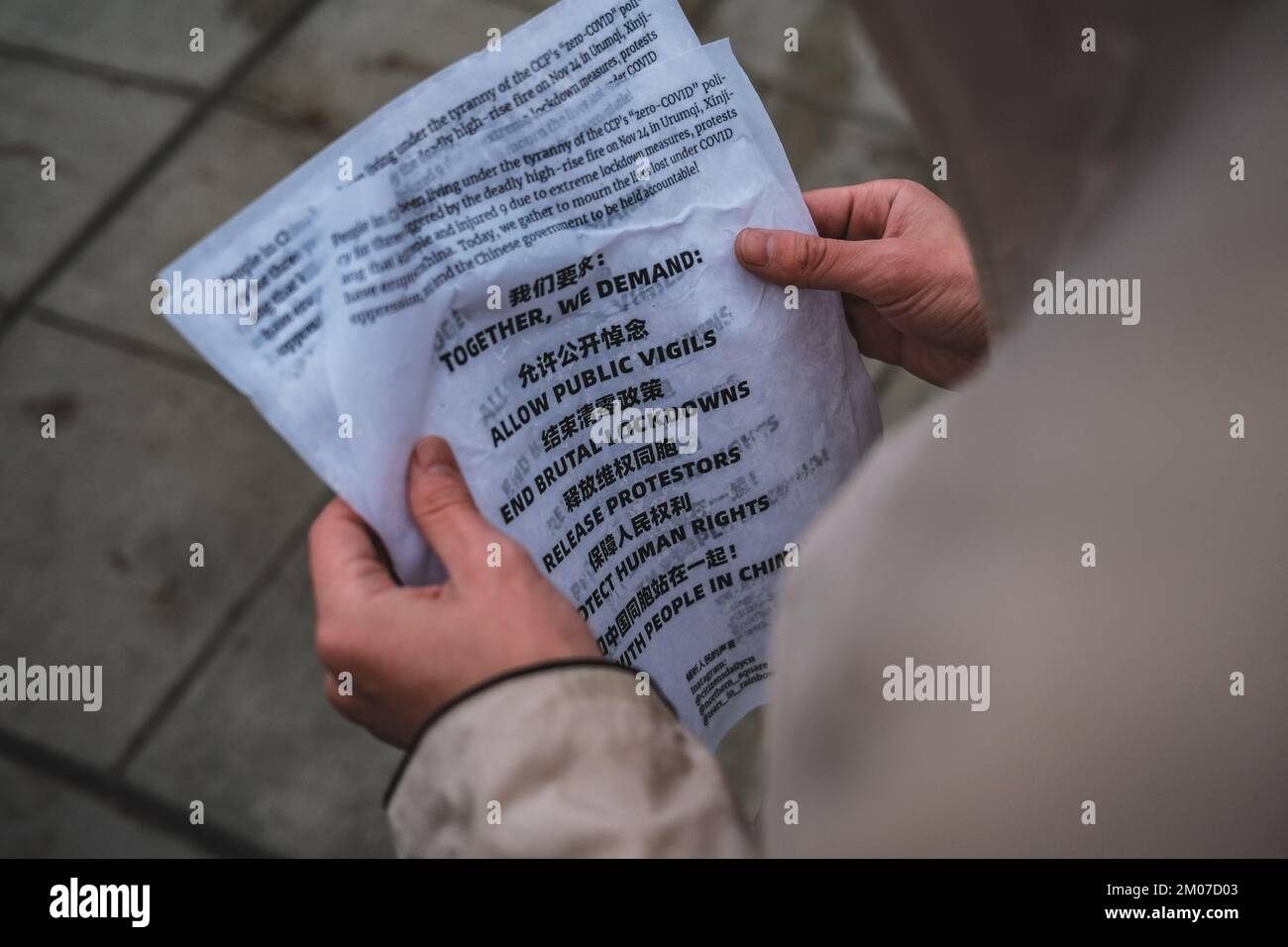 A protester holds a leaflet about the six demands of the "white paper ...