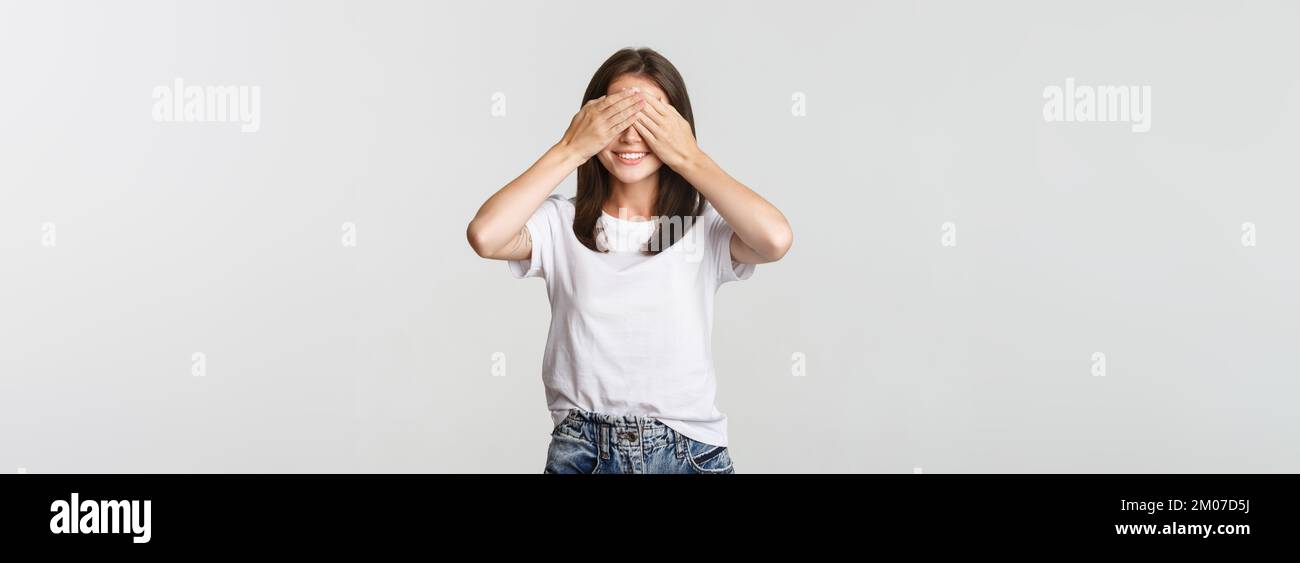 Dreamy beautiful girl smiling and waiting for surprise with shut eyes ...