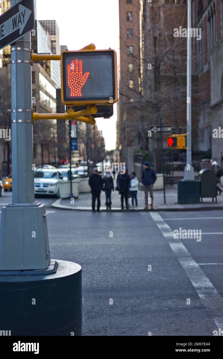 Metal pole on a new york corner with red hand lighted sign of no ...