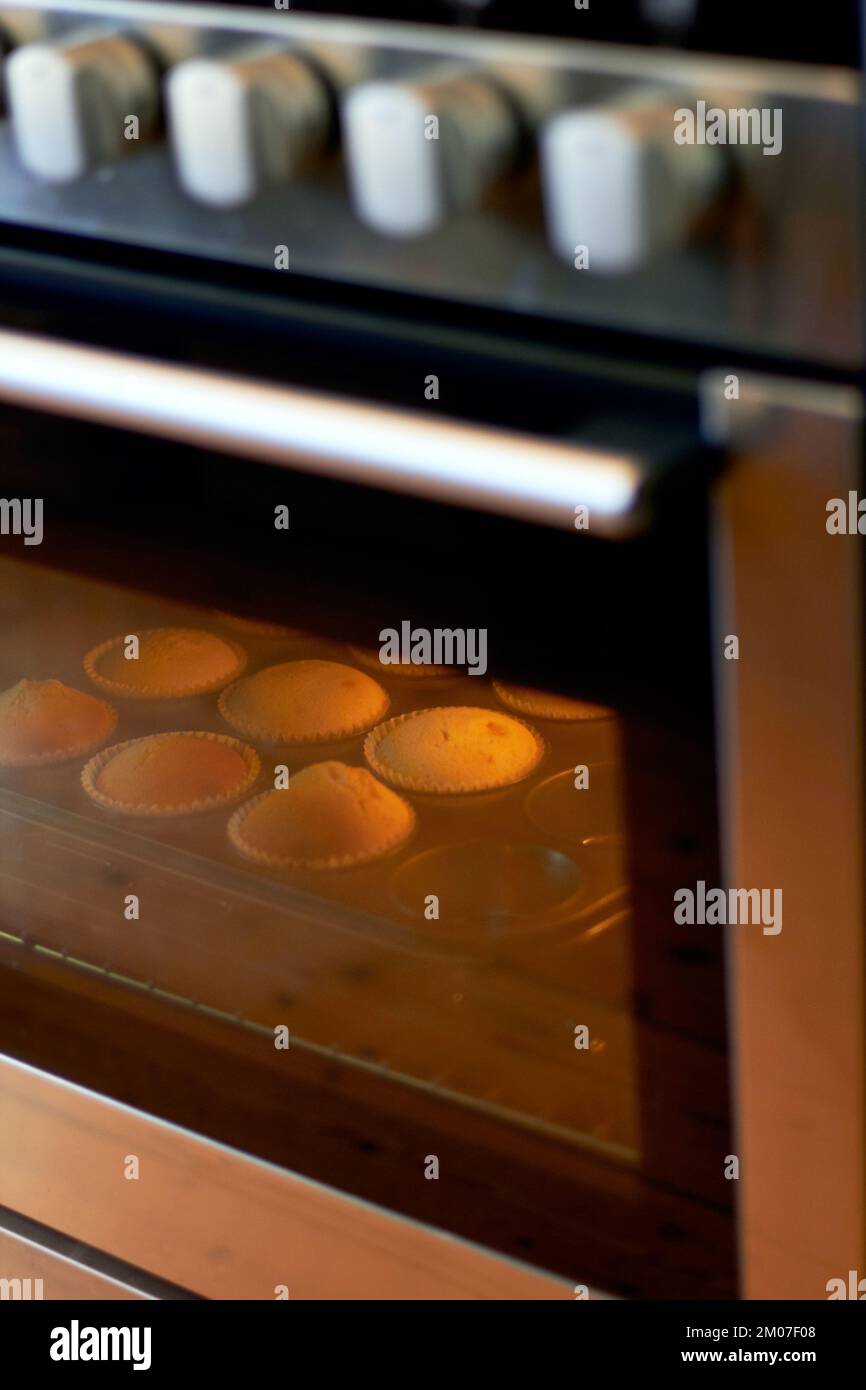 Waiting for deliciousness. cupcakes baking in an oven Stock Photo - Alamy
