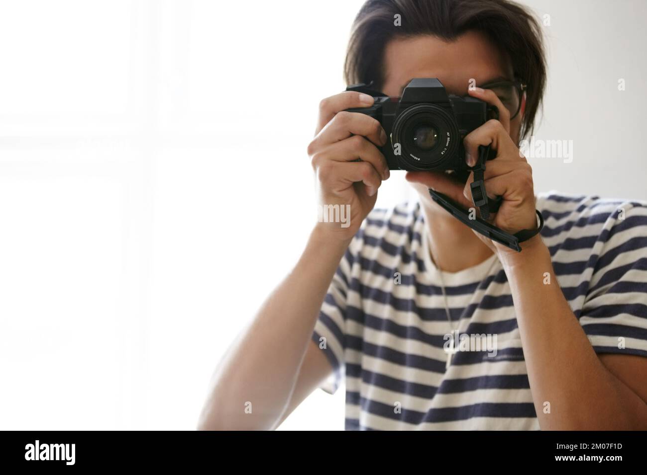 Smile. Cropped view of a young guy holding up a camera to get a shot ...