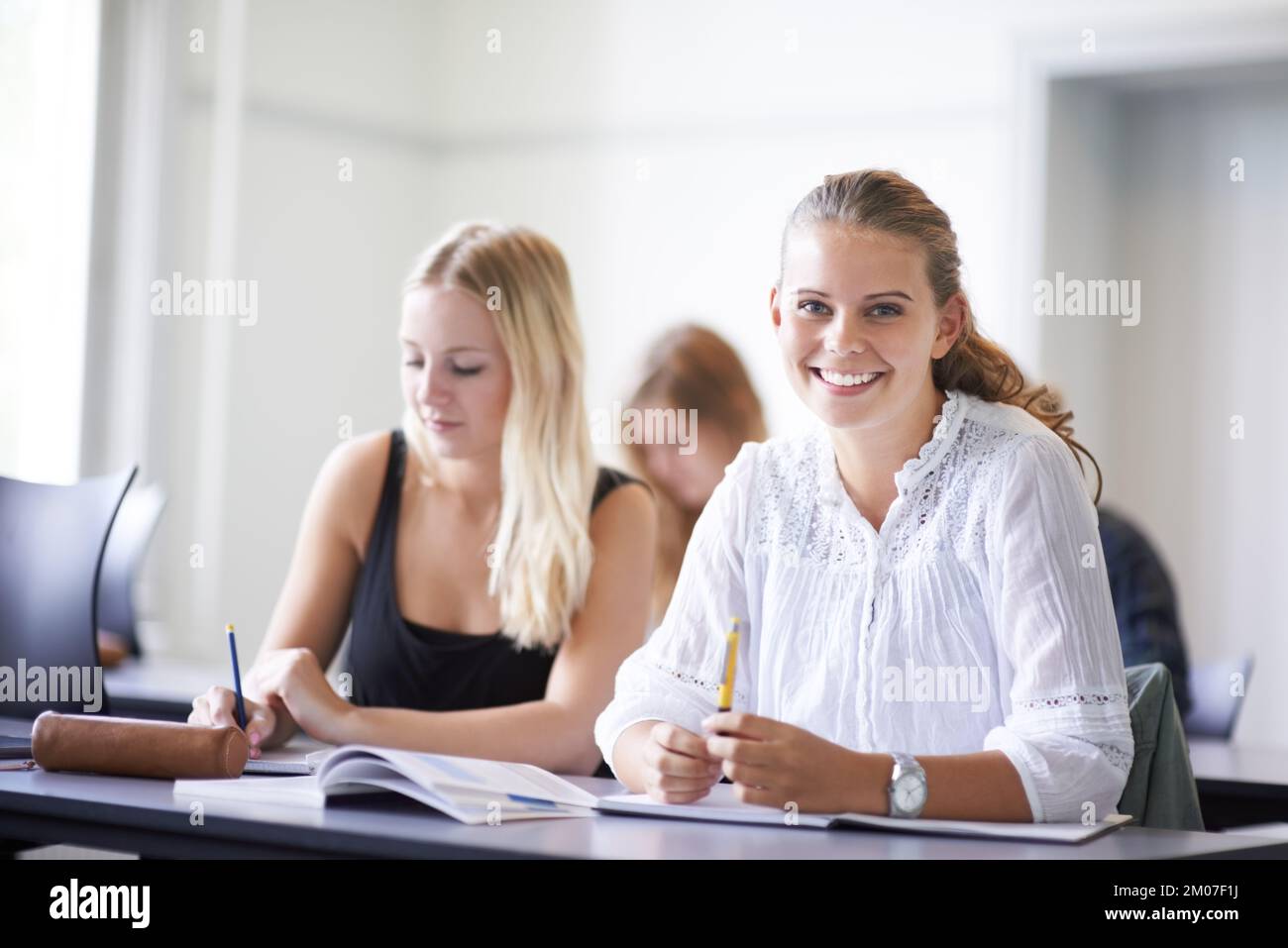 Shes an A student. A smiling teenage girl sitting in a classroom Stock ...