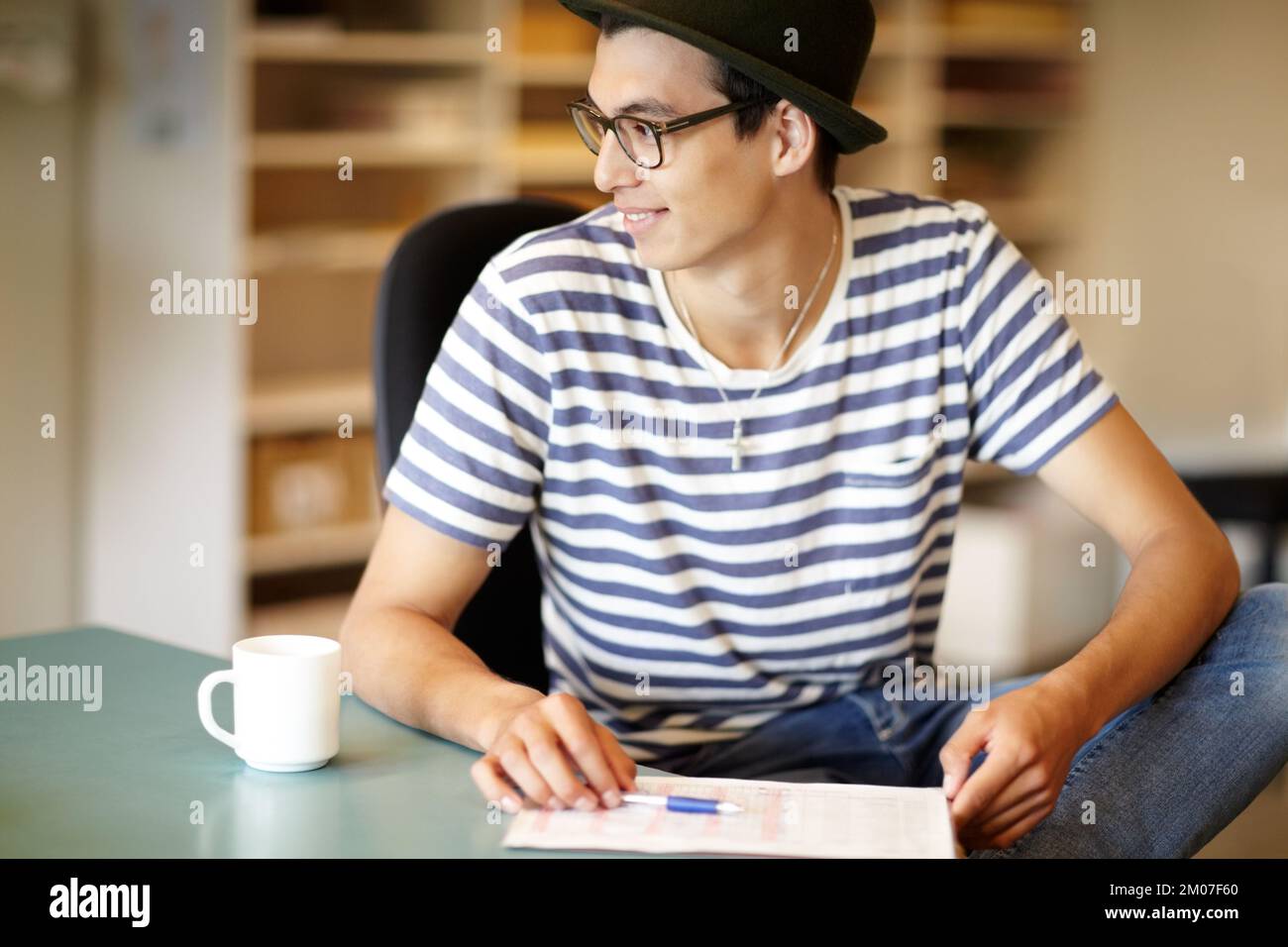 Taking some time out. Young guy looking away while enjoying his morning ...